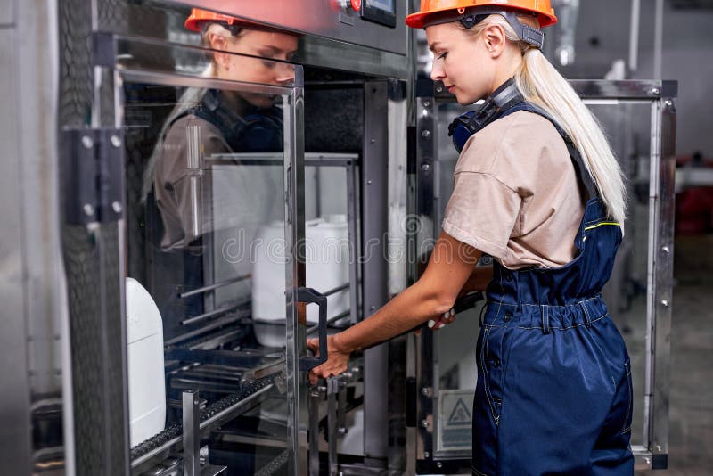 Female Worker in Factory Preparing Robotic Line for Bottling and ...