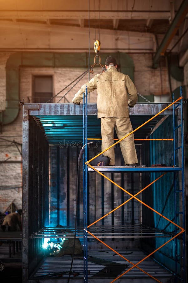Worker at the Factory To Weld the Iron Container with a Semi-automatic ...