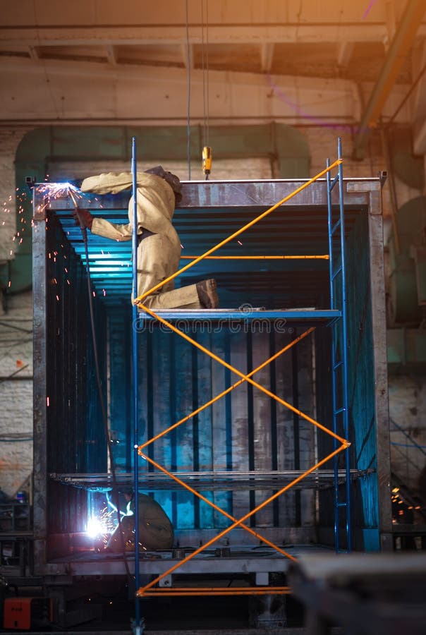 Worker at the Factory To Weld the Iron Container with a Semi-automatic ...