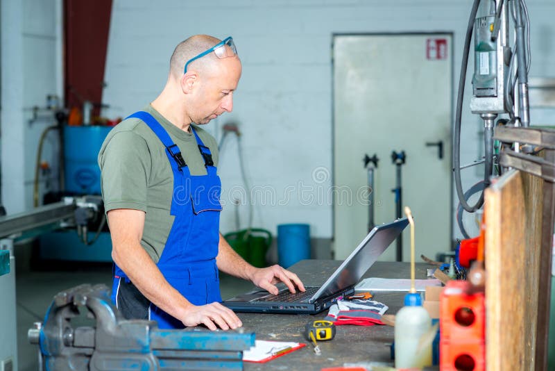 Worker in Factory on Work Bench with Computer Stock Photo - Image of ...