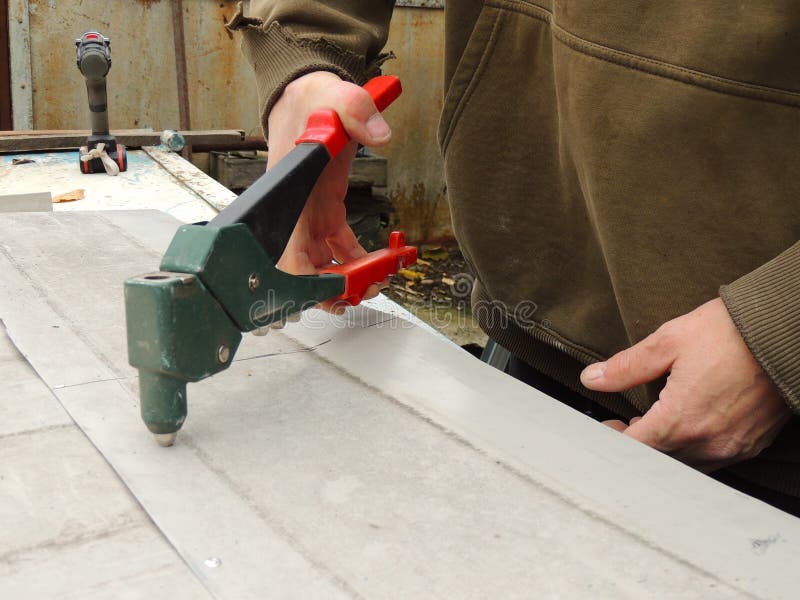 A Worker Fastens the Plates with a Riveting Tool Stock Image - Image of ...