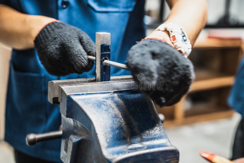 Worker File a Hole in a Piece of Metal in Workshop. Stock Image - Image ...