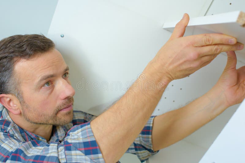 Worker fitting a kitchen stock photo. Image of work - 130823120