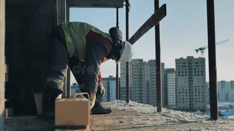 A Worker is Fixing Bricks in Lines in a Multistory House in Progress ...