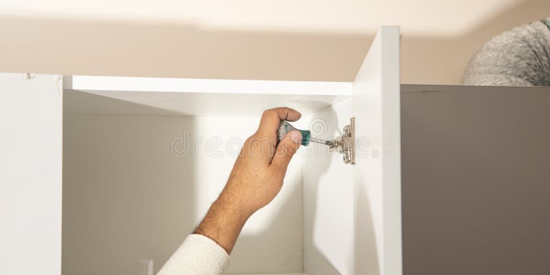 Worker Fixing Kitchen Cabinet Using Screwdriver Stock Photo - Image of ...