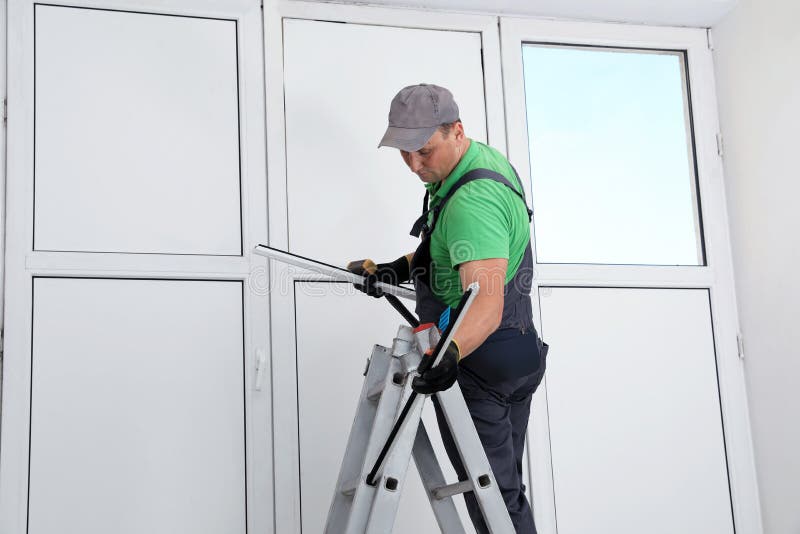 Worker on Folding Ladder Installing Window Indoors Stock Image - Image ...
