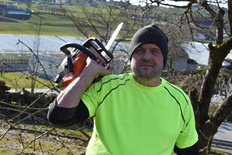 Worker in the Garden with a Chainsaw. Stock Image - Image of garden ...