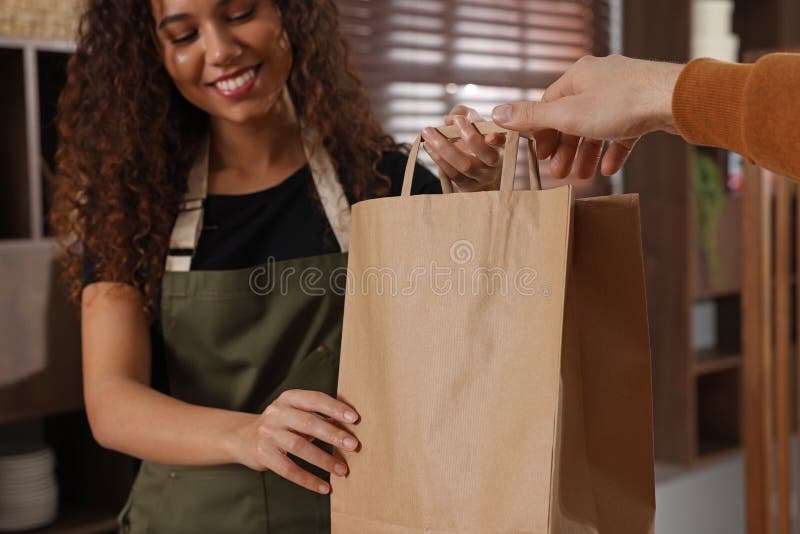 Worker Giving Paper Bag To Customer in Cafe, Closeup Stock Image ...
