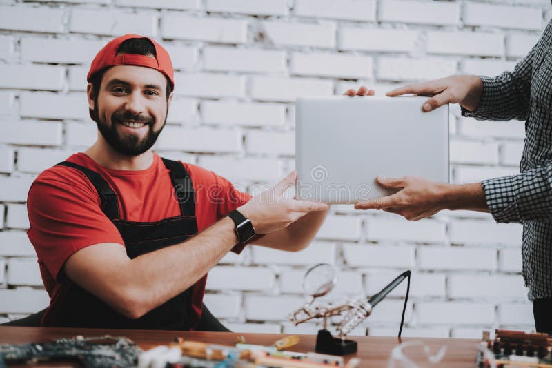 Worker Giving To Man Fixed Laptop in Workshop. Stock Photo - Image of ...