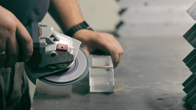 Worker Grinding Metal Piece in a Workshop. a Close-up of a Worker Using ...