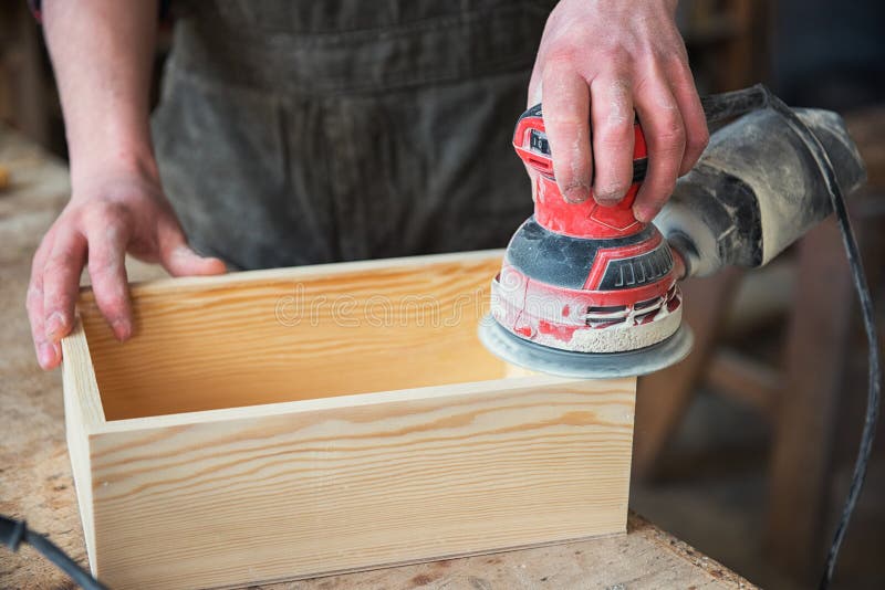 Worker grinds the wood box stock photo. Image of industrial - 140597738