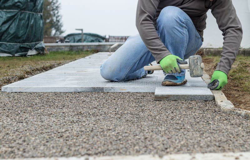 Worker Hammering the Stone Plates To Install Footpath Stock Photo ...