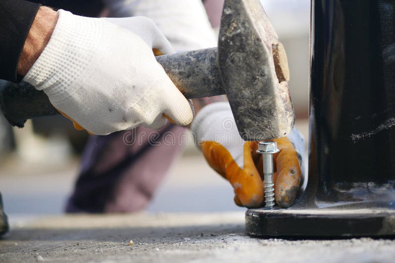 A Worker Hammers a Bolt into a Large Construction Structure for ...
