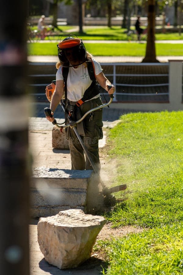 A Worker with a Hand-held Lawn Editorial Photo - Image of cutting ...