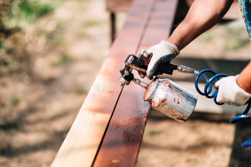 Hands in Carpentry Industry. Manual Painting of Timber with Brown Paint ...