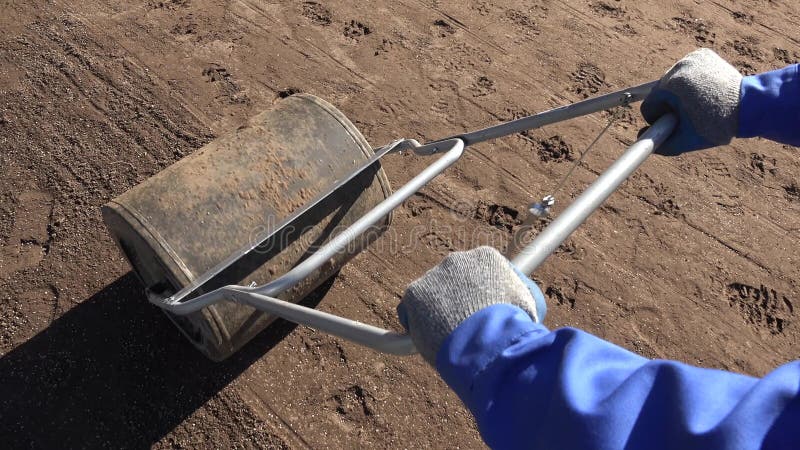 Worker Hands in Gloves Push Heavy Roller Soil Compactor in Yard ...