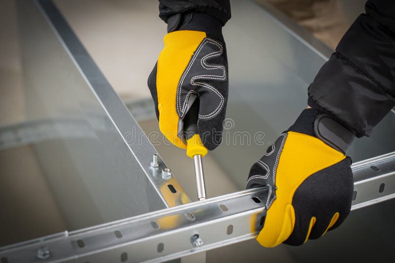 Worker Hands in Safety Gloves Mounting Modular Steel Components Using a ...