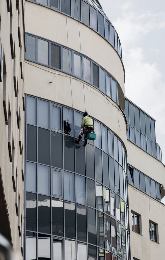 A Worker at a Height Washes the Windows Stock Photo - Image of ...
