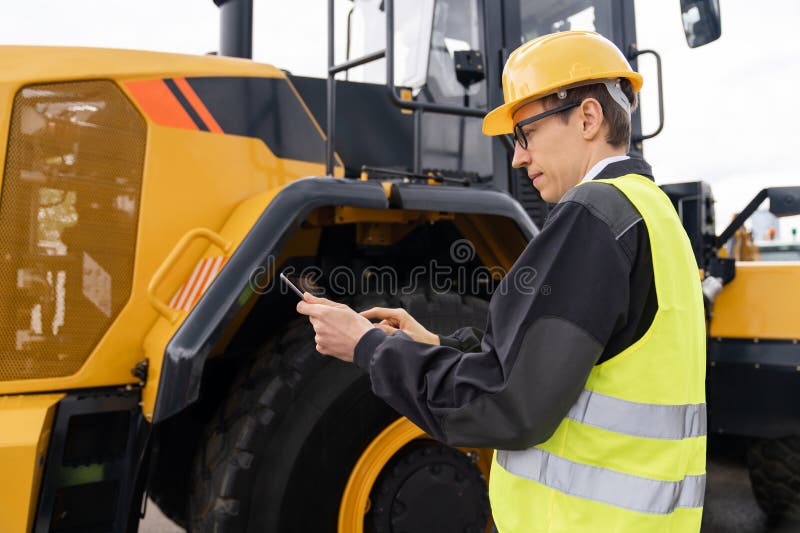 Worker in a Helmet with a Digital Tablet on the Background of ...