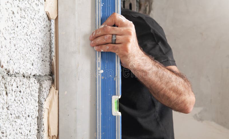 Worker Holding a Level Against the Wall Stock Image - Image of tool ...