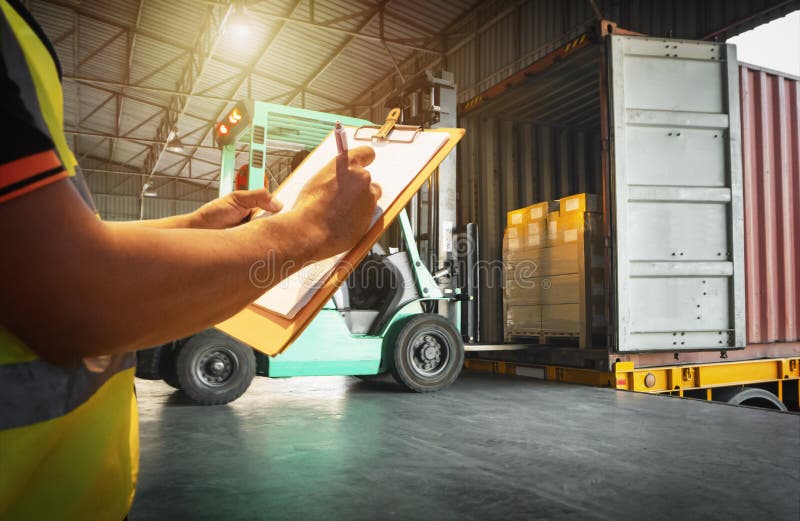 Worker Holds a Clipboard Checking the Loading Cargo Shipment at ...