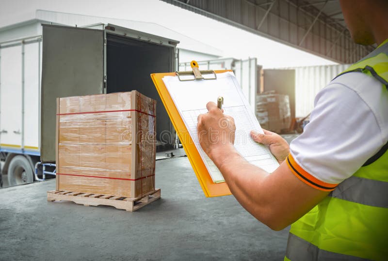 Worker Holds a Clipboard Controlling the Loading of Cargo into Shipping ...