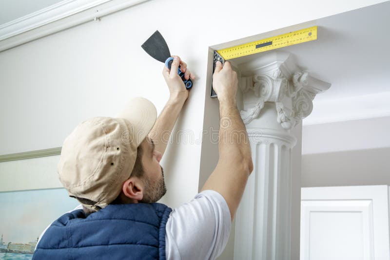 Worker Holds Putty Knife and Measures the Wall Corner Using Metal Angle ...