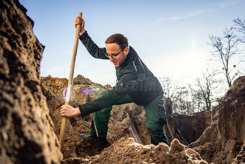 Worker Inside a Large Hole Digging with a Shovel Stock Image - Image of ...