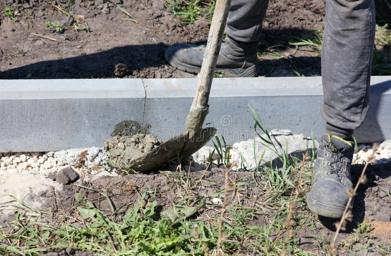 A Worker is Installing a Concrete Curb at a Construction Site. Stock ... A Worker is Installing a Concrete Curb at a Construction Site. Stock ...