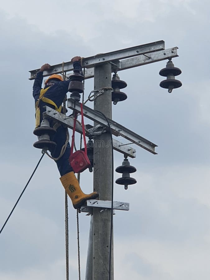 A Worker is Installing an Electric Cable on a Power Pole Stock Image ...