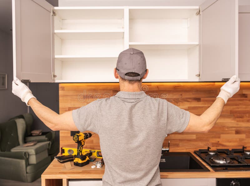 Man Installing Kitchen Cabinets in a Modern Home during a Home ...