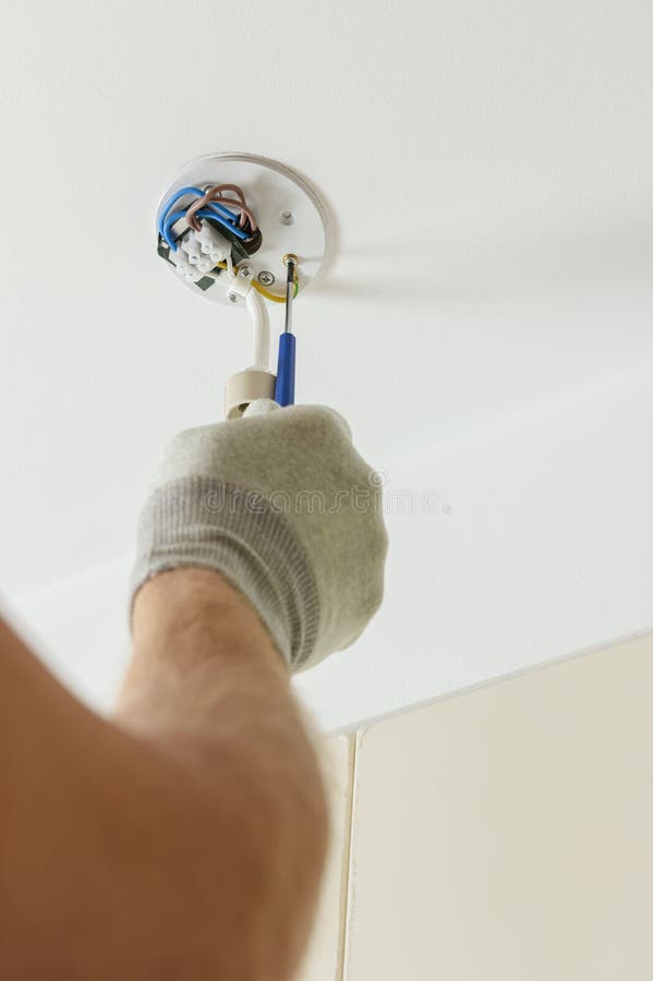 A Worker is Installing an LED Spotlight on the Ceiling Stock Photo ...