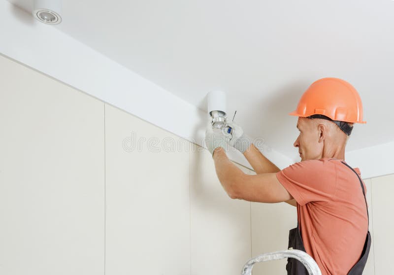 A Worker is Installing an LED Spotlight on the Ceiling Stock Photo ...