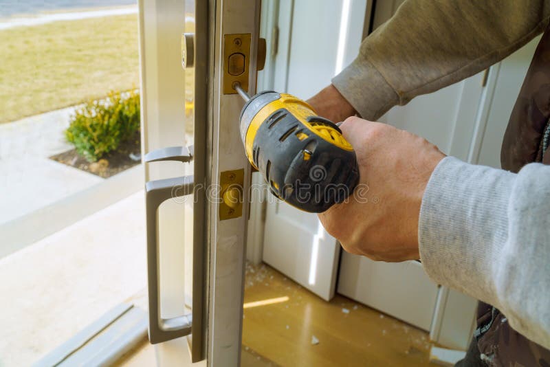 Worker Installing Lock in the New House with a Using Screwdriver Stock ...