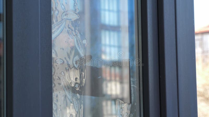 Worker Installing and Smoothing Tint Film on Window at Home. Man ...