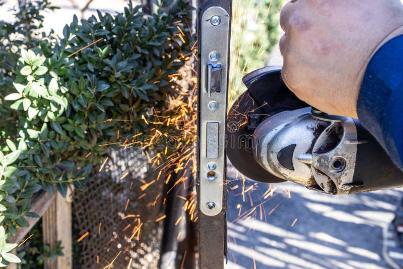 Worker Installs Door Lock in Wicket with Grinder Stock Photo - Image of ...