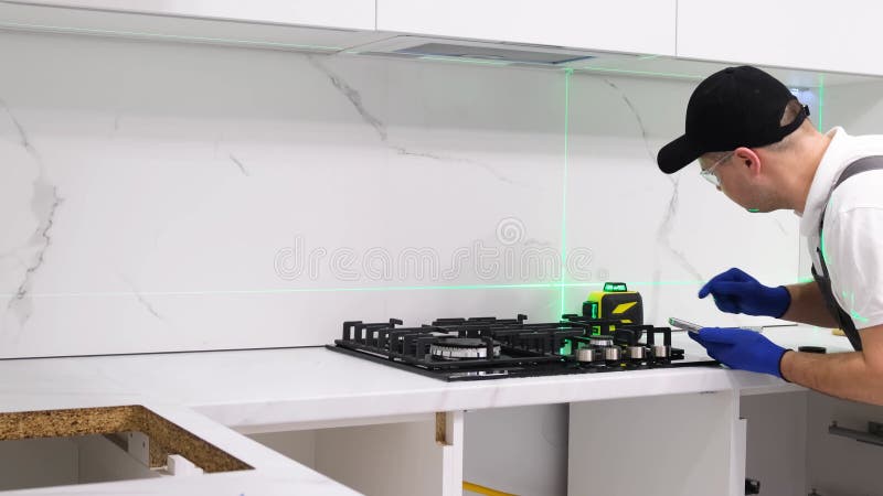 A Worker Installs a Gas Stove. Repair of the Kitchen Stove Stock Video ...