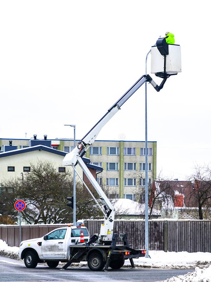 Worker Installs LED Street Lighting Using a Lifting Platform Mounted on ...