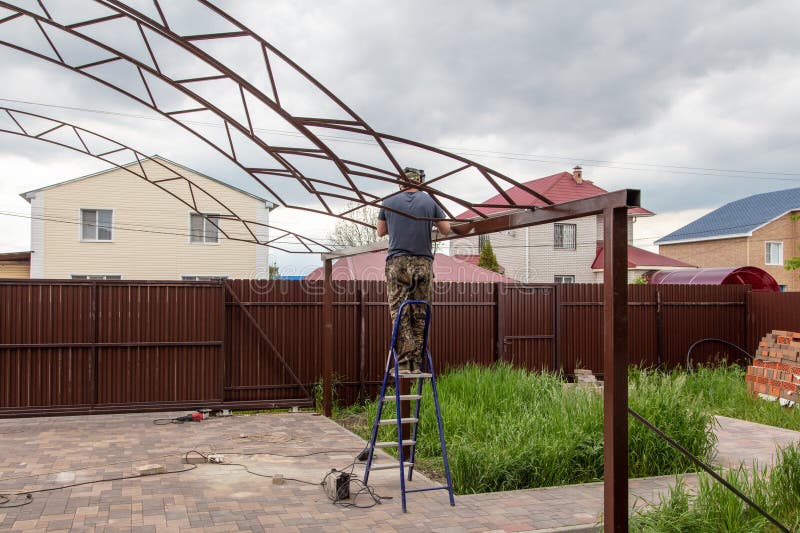 The Worker Installs the Metal on the Canopy. Stock Image - Image of ...