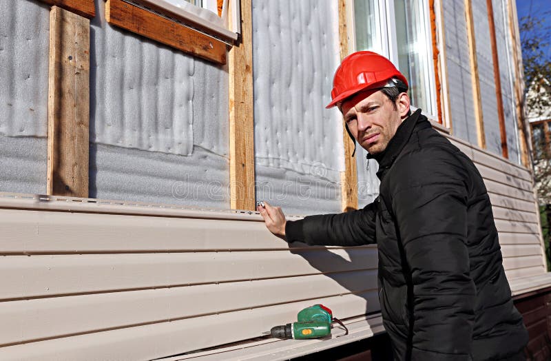 A Worker Installs Panels Beige Siding on the Facade Stock Photo - Image ...