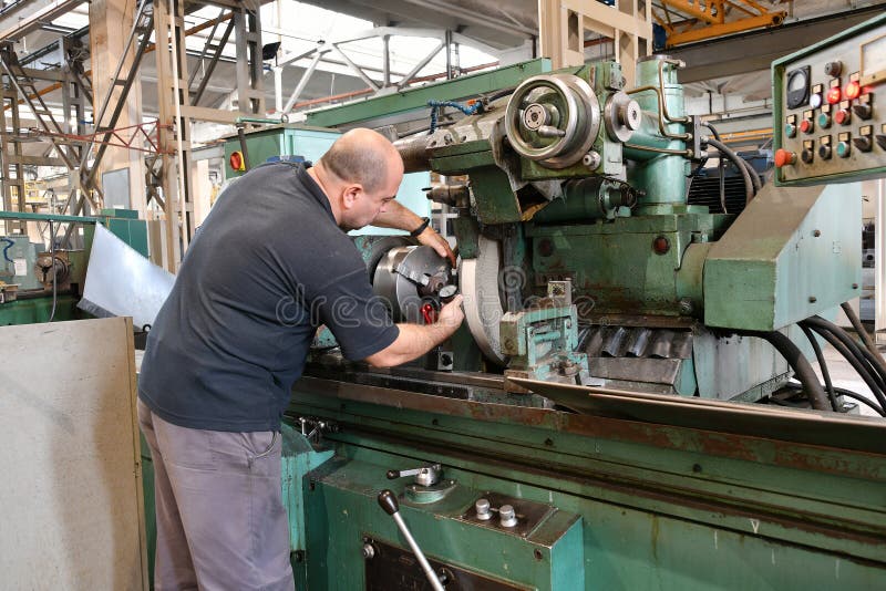 The Worker Installs the Part in the Chuck of the Grinding Machine for ...