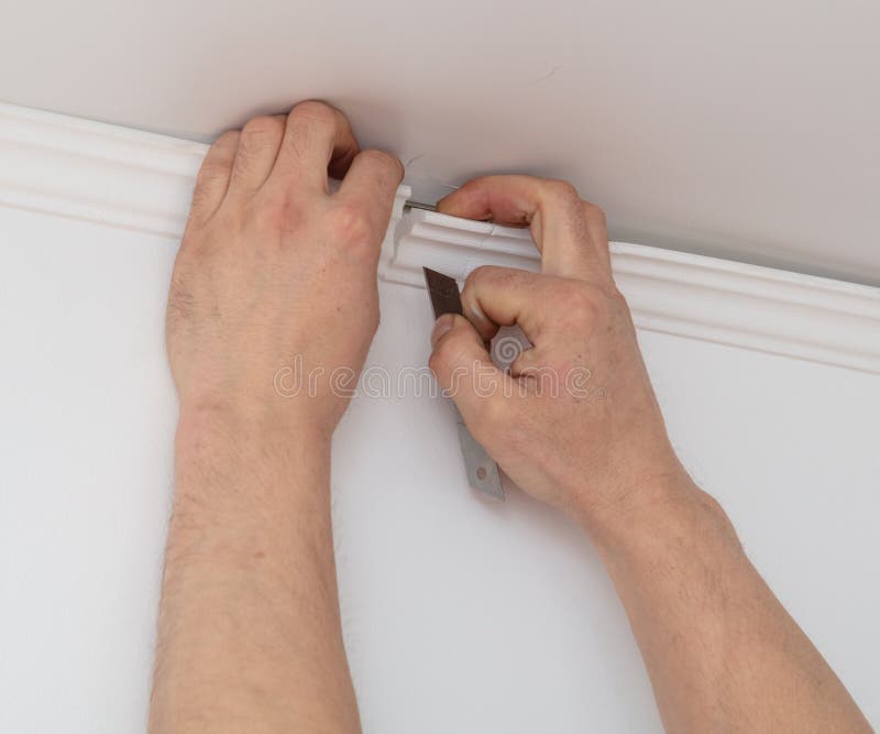 A Worker Installs a Skirting Board on the Ceiling Stock Photo - Image ...
