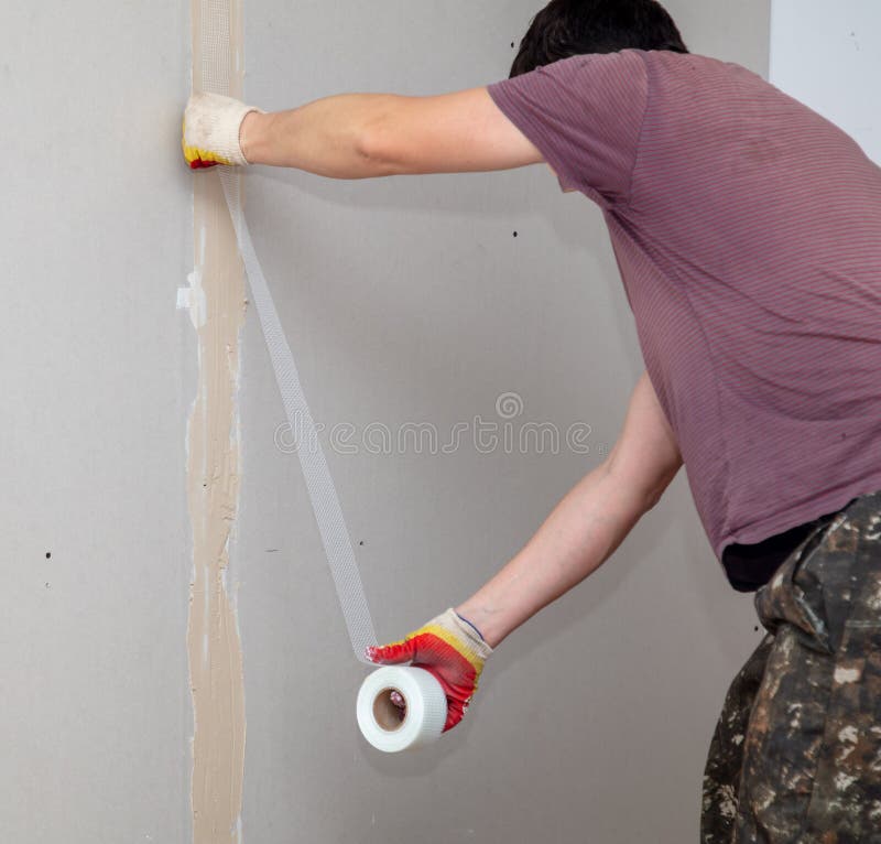 A Worker Installs Tape on a Wall for Plastering Stock Photo - Image of ...