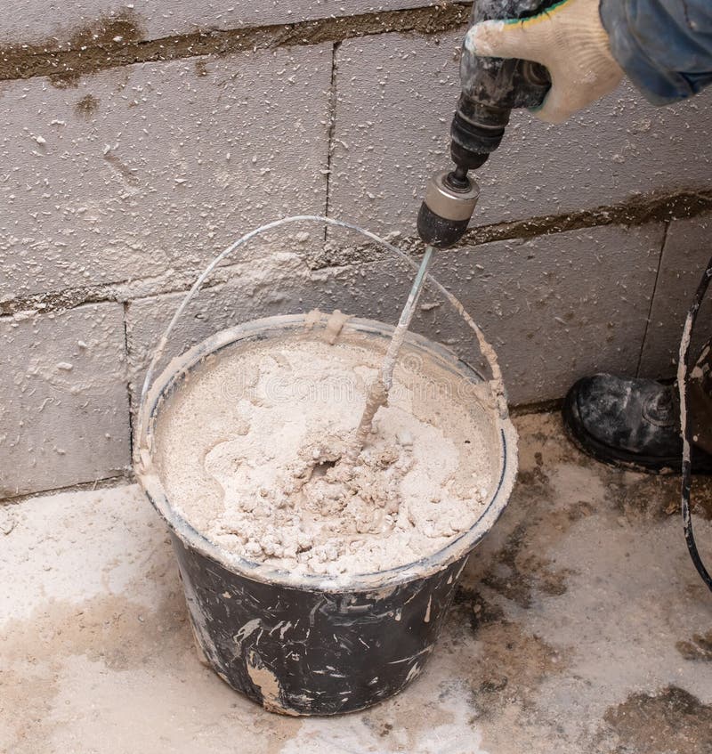 A Worker Kneads the Mixture into Plaster Buckets. Home Renovation Stock ...