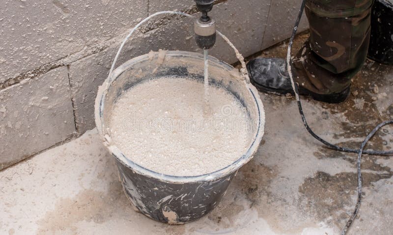 A Worker Kneads the Mixture into Plaster Buckets. Home Renovation Stock ...