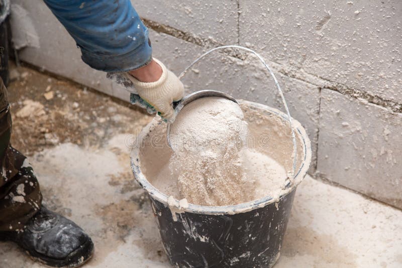 A Worker Kneads the Mixture into Plaster Buckets. Home Renovation Stock ...