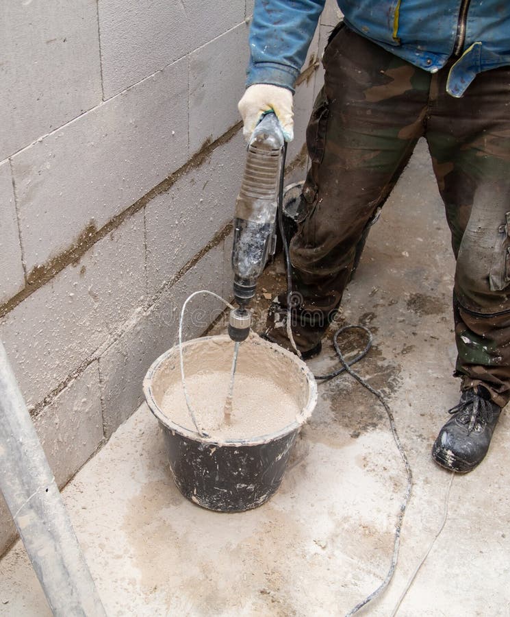 A Worker Kneads the Mixture into Plaster Buckets. Home Renovation Stock ...