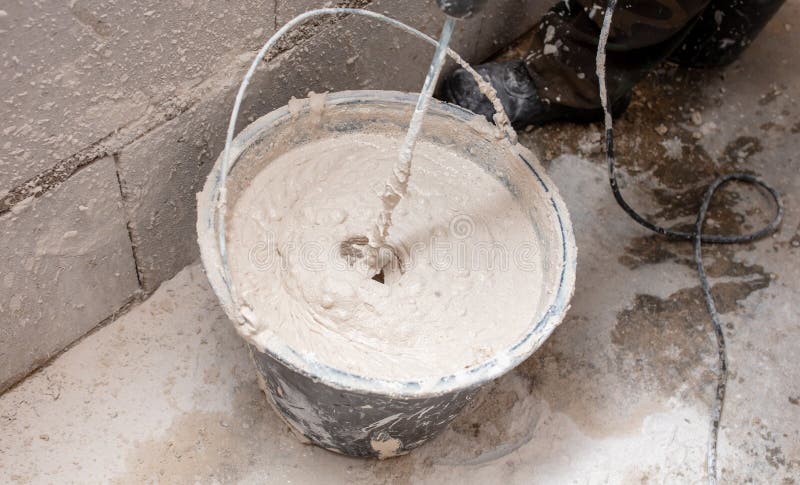 A Worker Kneads the Mixture into Plaster Buckets. Home Renovation Stock ...