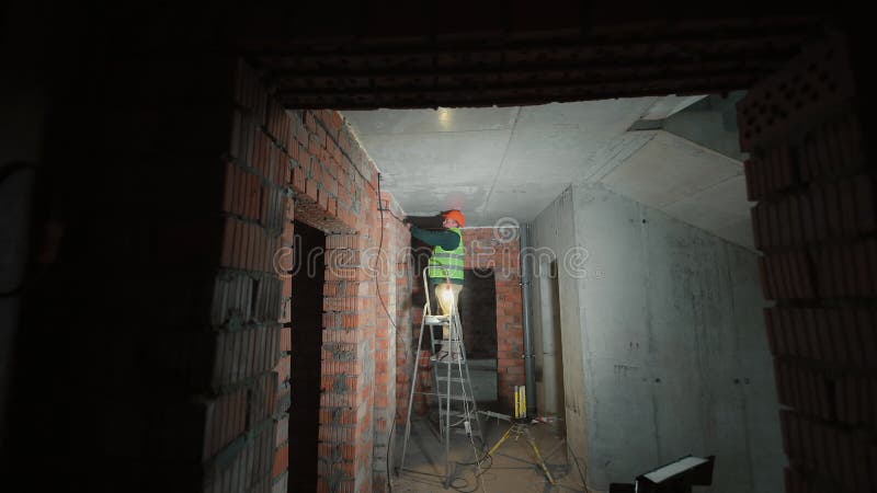 Worker on Ladder Installing Cables Inside Unfinished Building, Worker ...