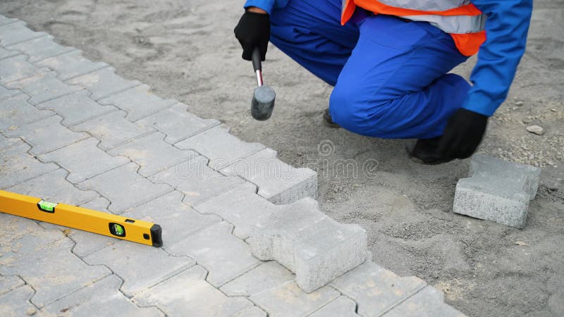 Worker Laying Interlocking Paving Stones on a Construction Site Stock ...